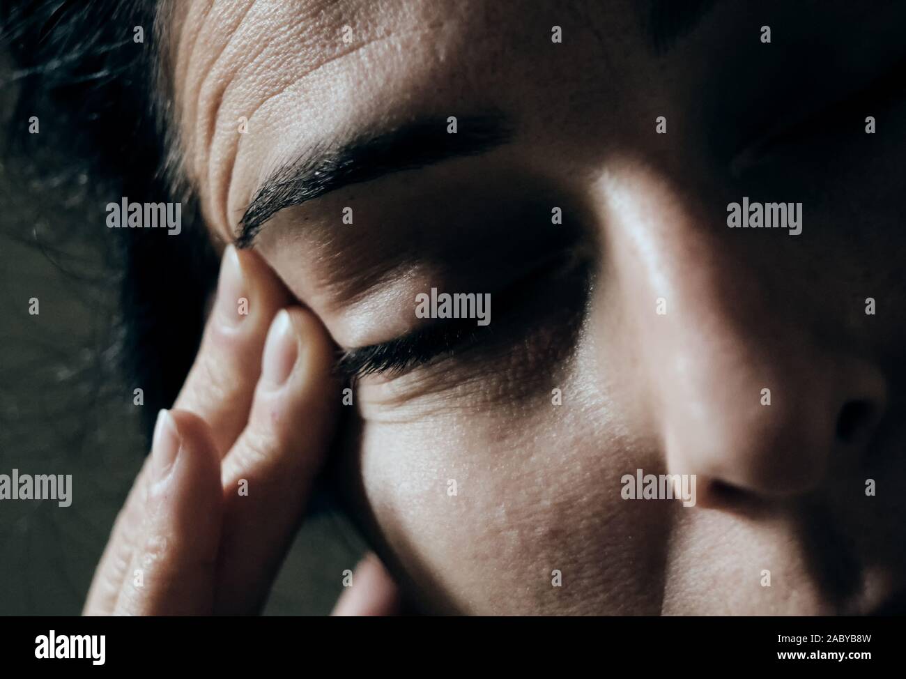 woman touching her forehead suffering from a headache or is stressed ...