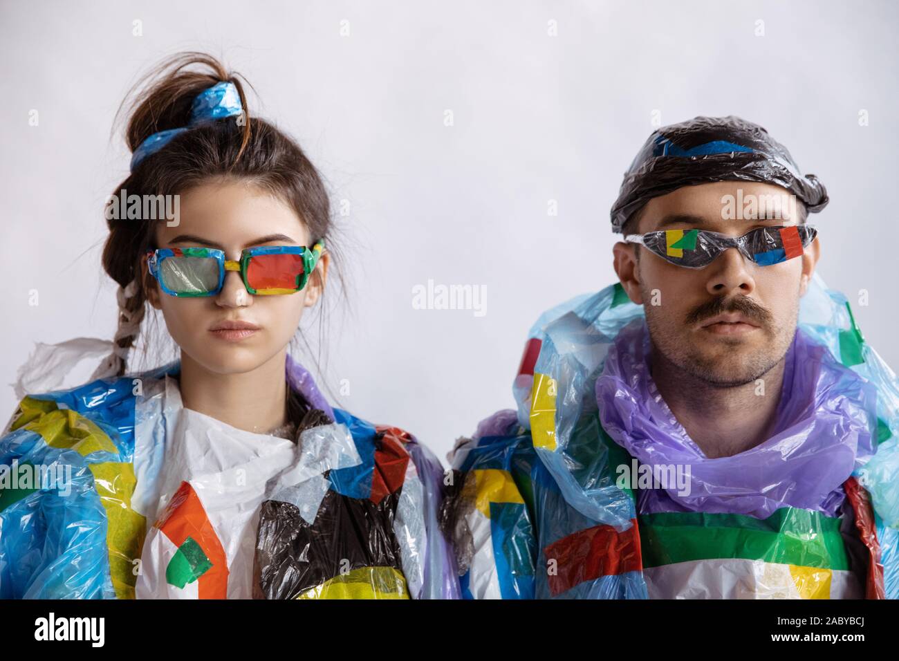 Woman and man wearing plastic on white background. Models in clothes ...