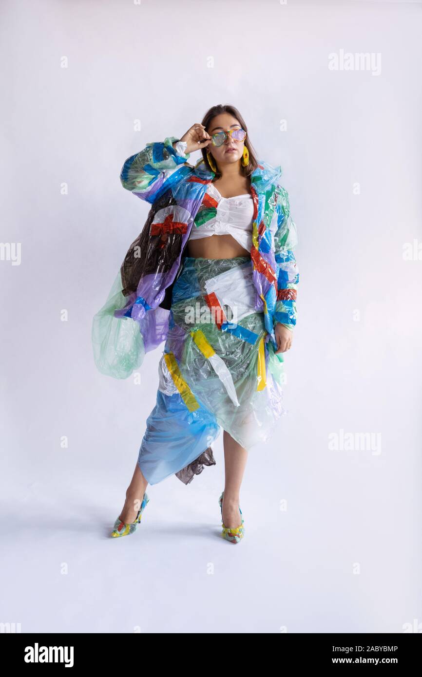 Woman wearing plastic on white background. Female model in clothes and ...