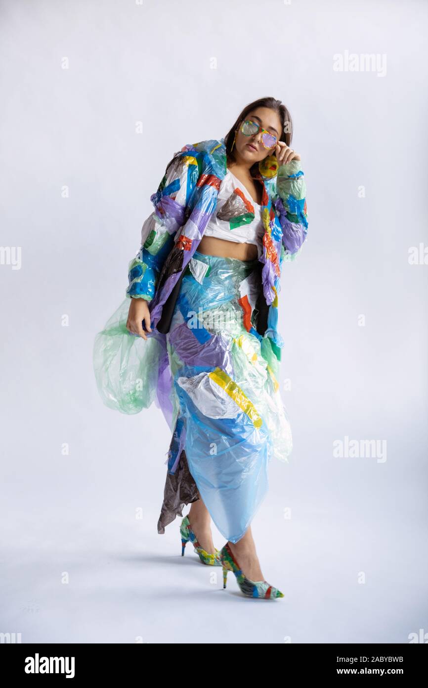 Woman wearing plastic on white background. Female model in clothes and ...
