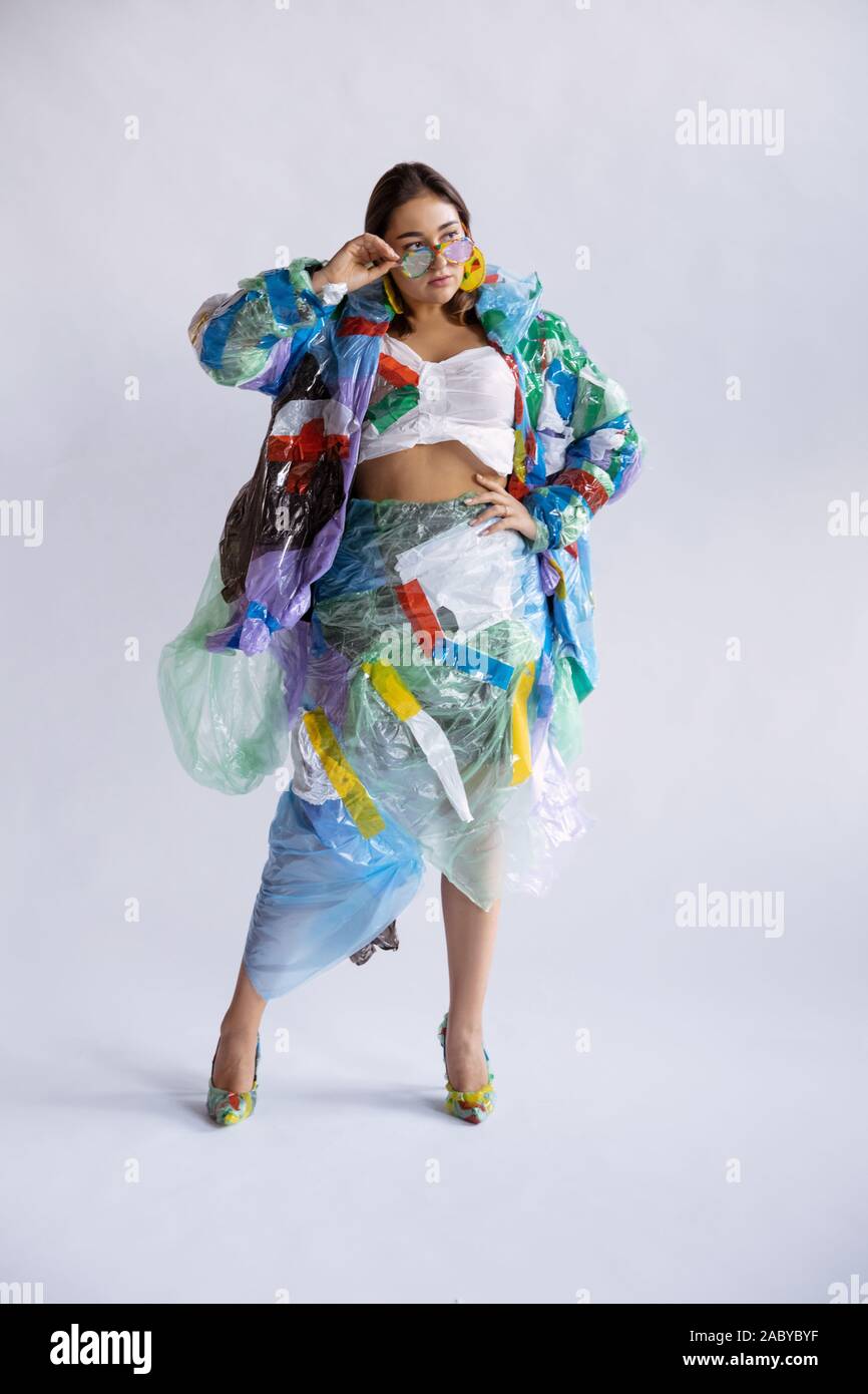 Woman wearing plastic on white background. Female model in clothes and ...