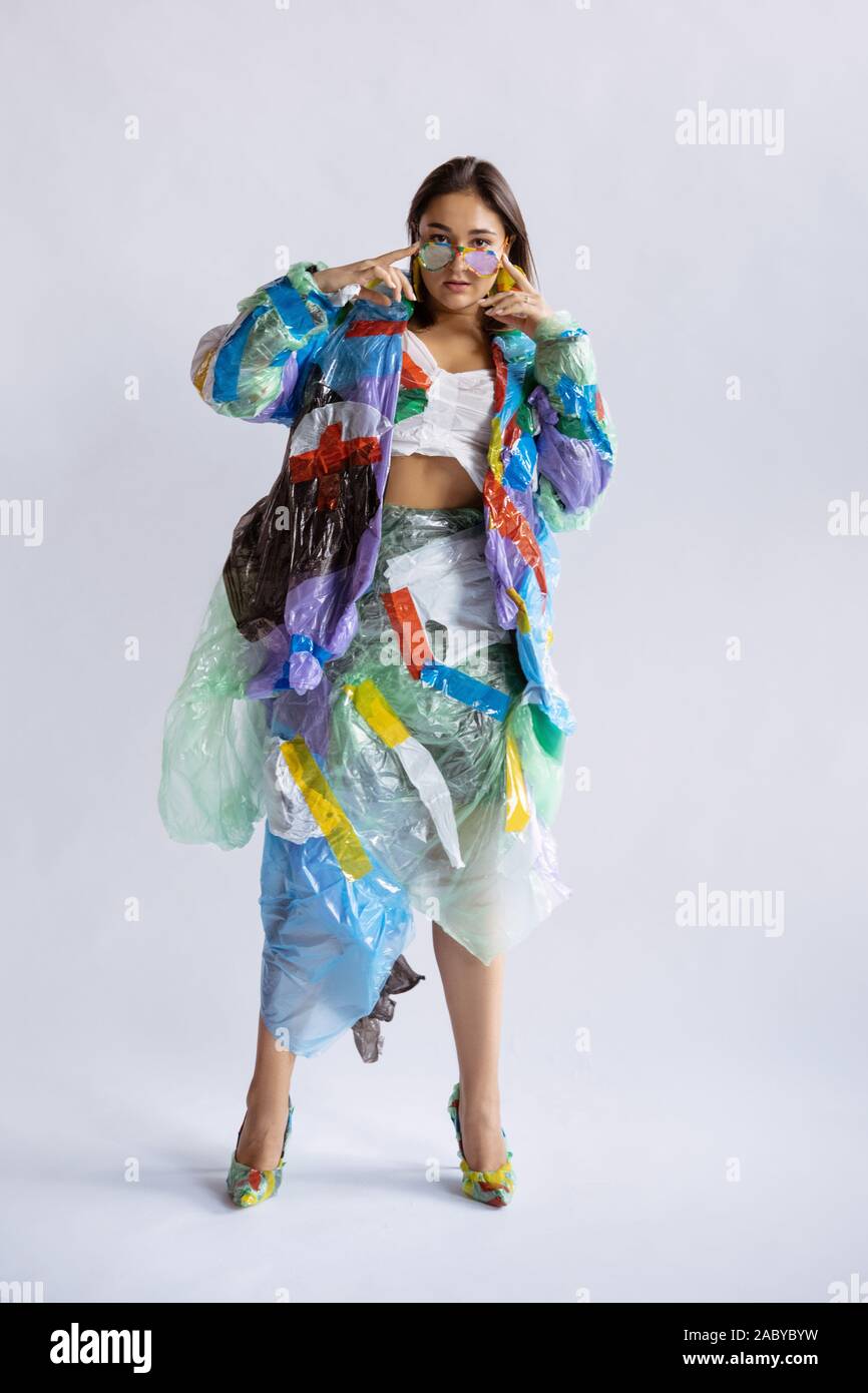 Woman wearing plastic on white background. Female model in clothes and ...