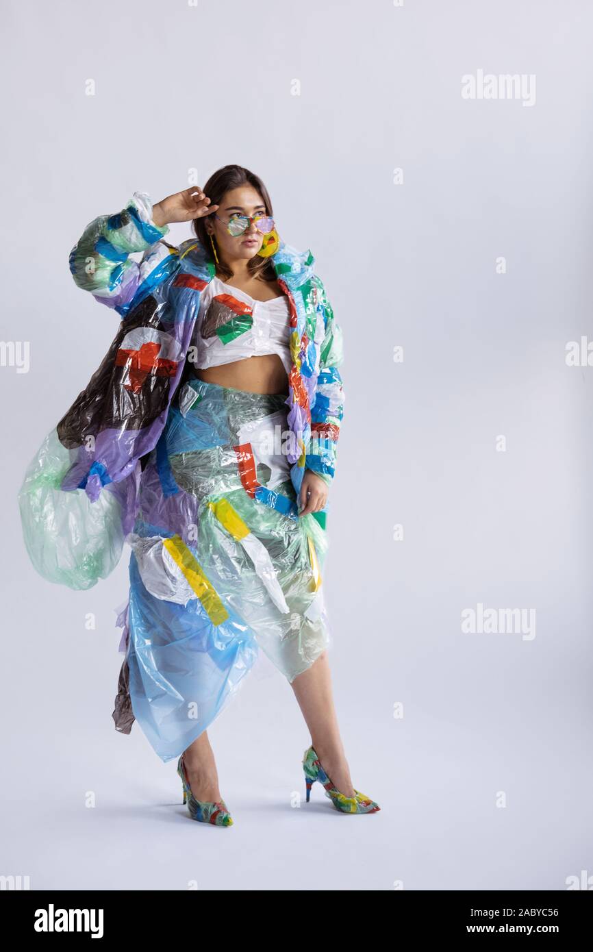 Woman wearing plastic on white background. Female model in clothes and ...