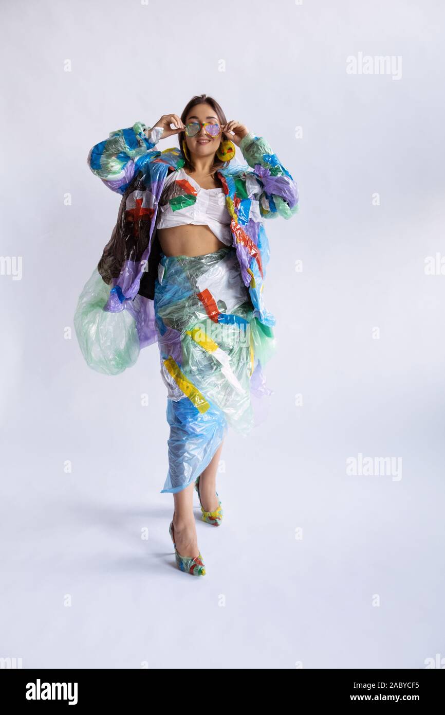 Woman wearing plastic on white background. Female model in clothes and ...