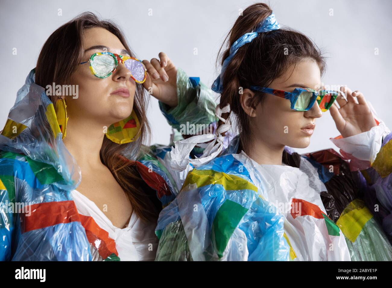 Women wearing plastic on white background. Female model in clothes and ...