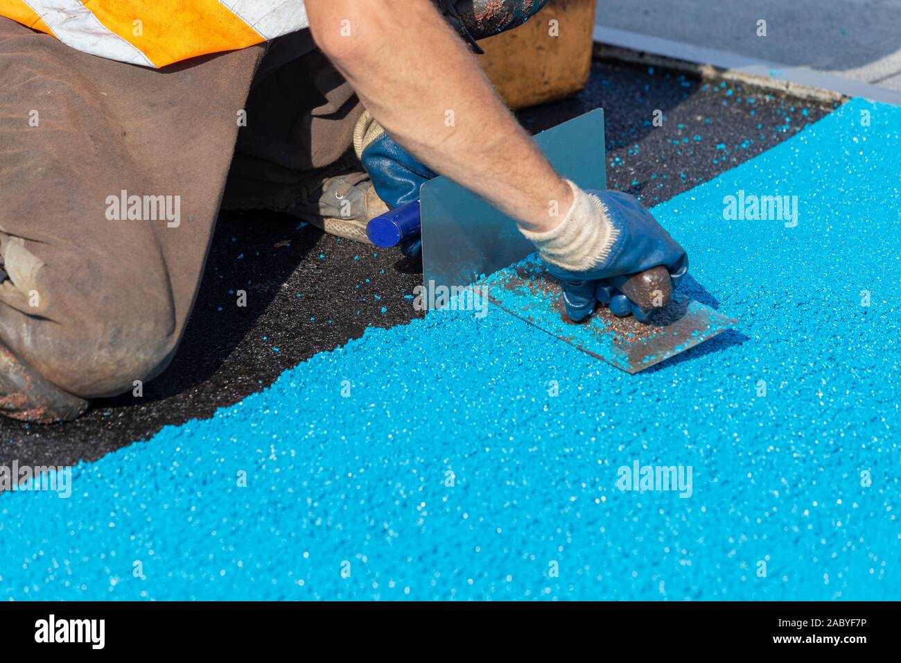 Mason leveling rubber mulch coating for playgrounds and sports, applied ...