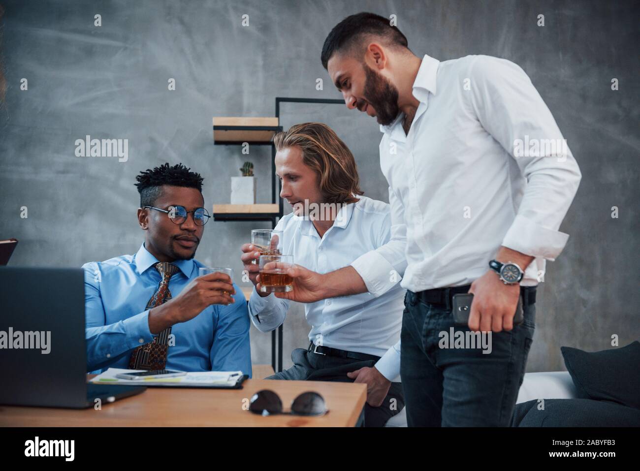 Drinking whiskey. Group of multiracial office workers in formal clothes ...