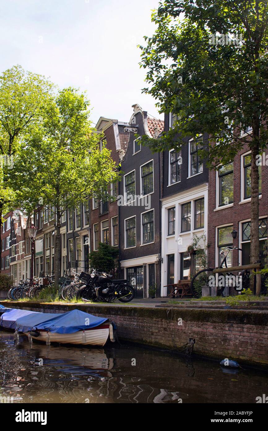 View of canal, trees, parked bicycles and boats, historical and ...