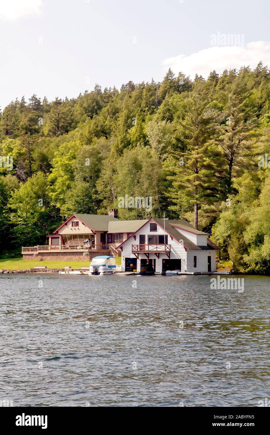 Large wooden house with a large boat house and pier next to a lake ...