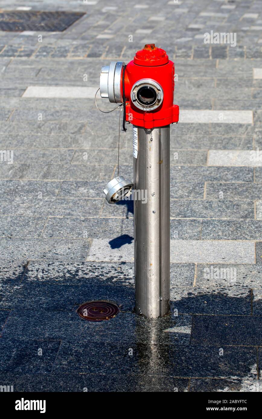 Red fire hydrant in street for emergency water access Stock Photo - Alamy