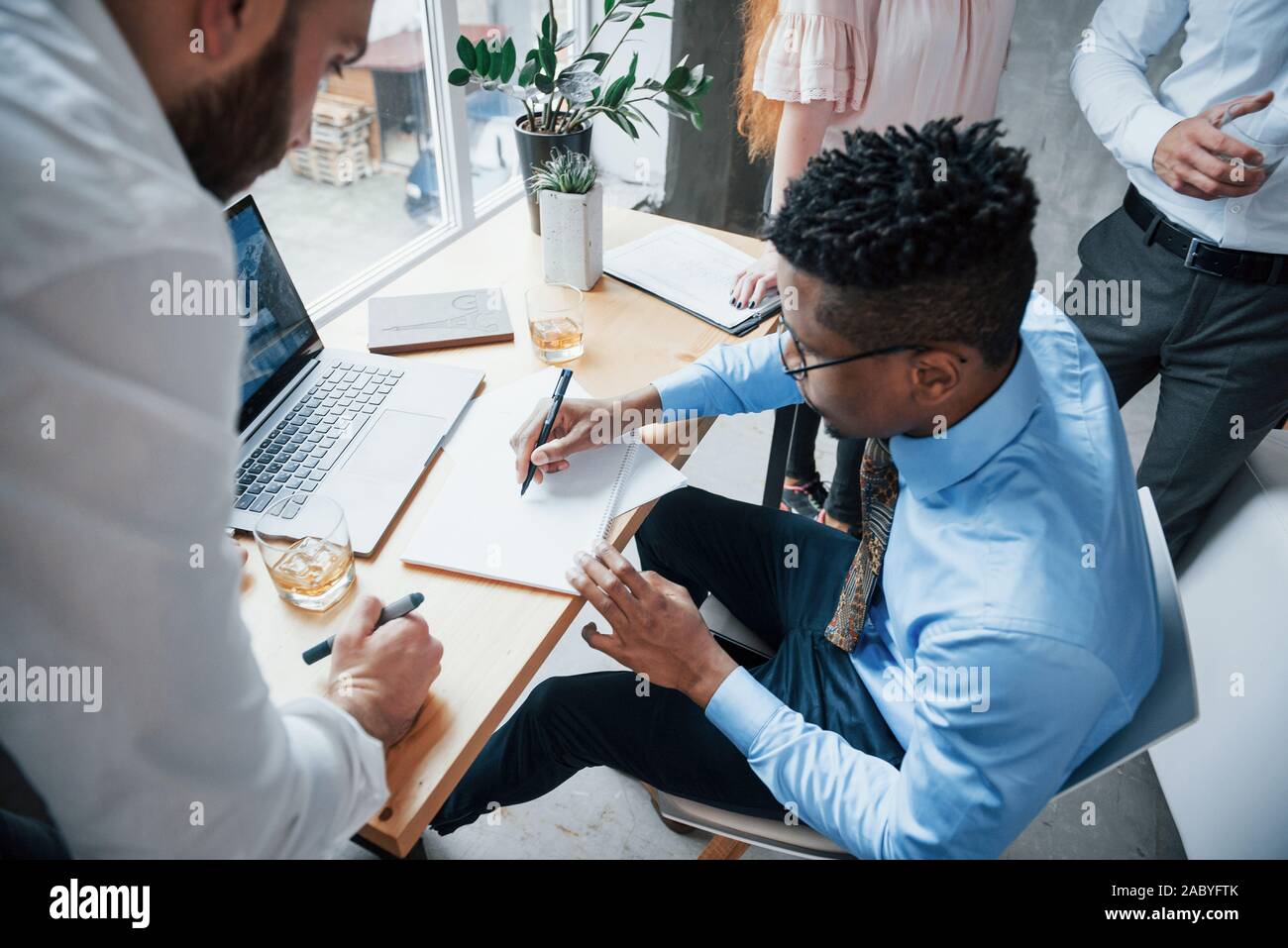 Top view. Office workers loaded with work and writing routine reports ...