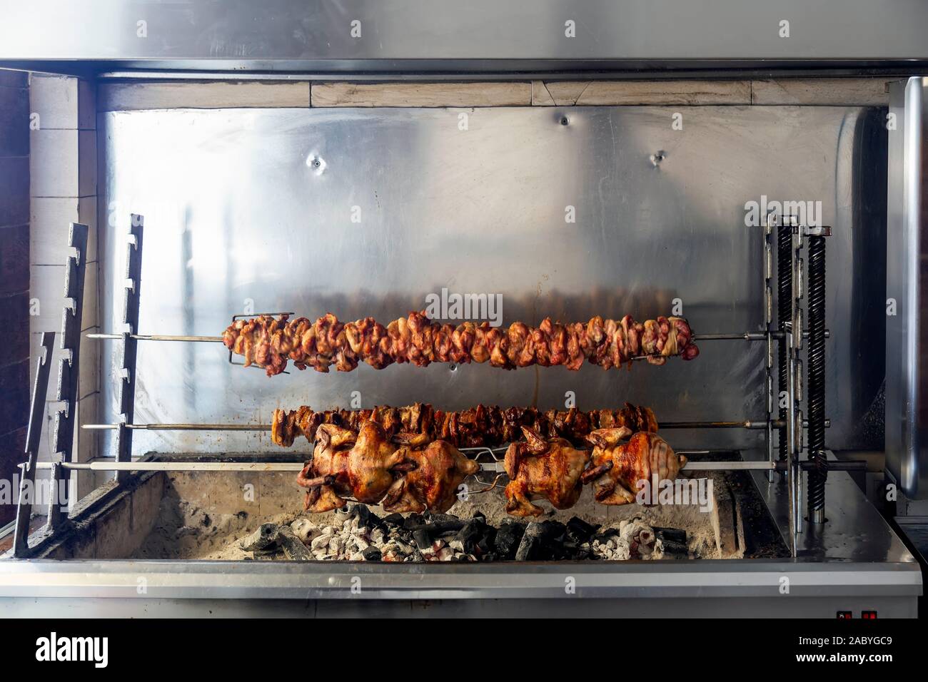 Stacked meat roasting on rotating horizontal spit for souvlaki ...
