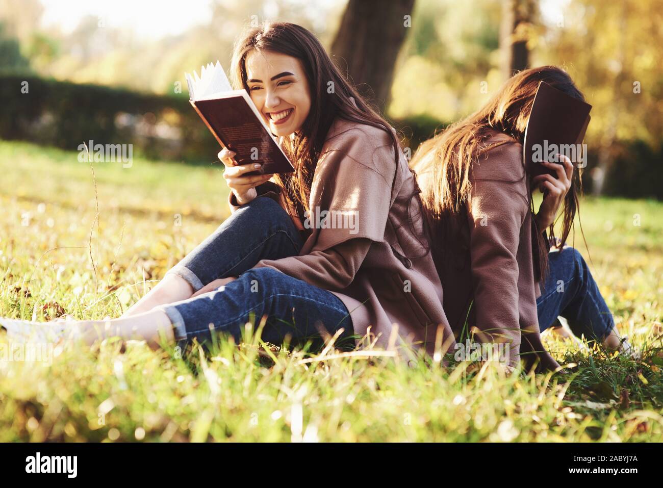 Twin sisters sitting back back hi-res stock photography and images - Alamy