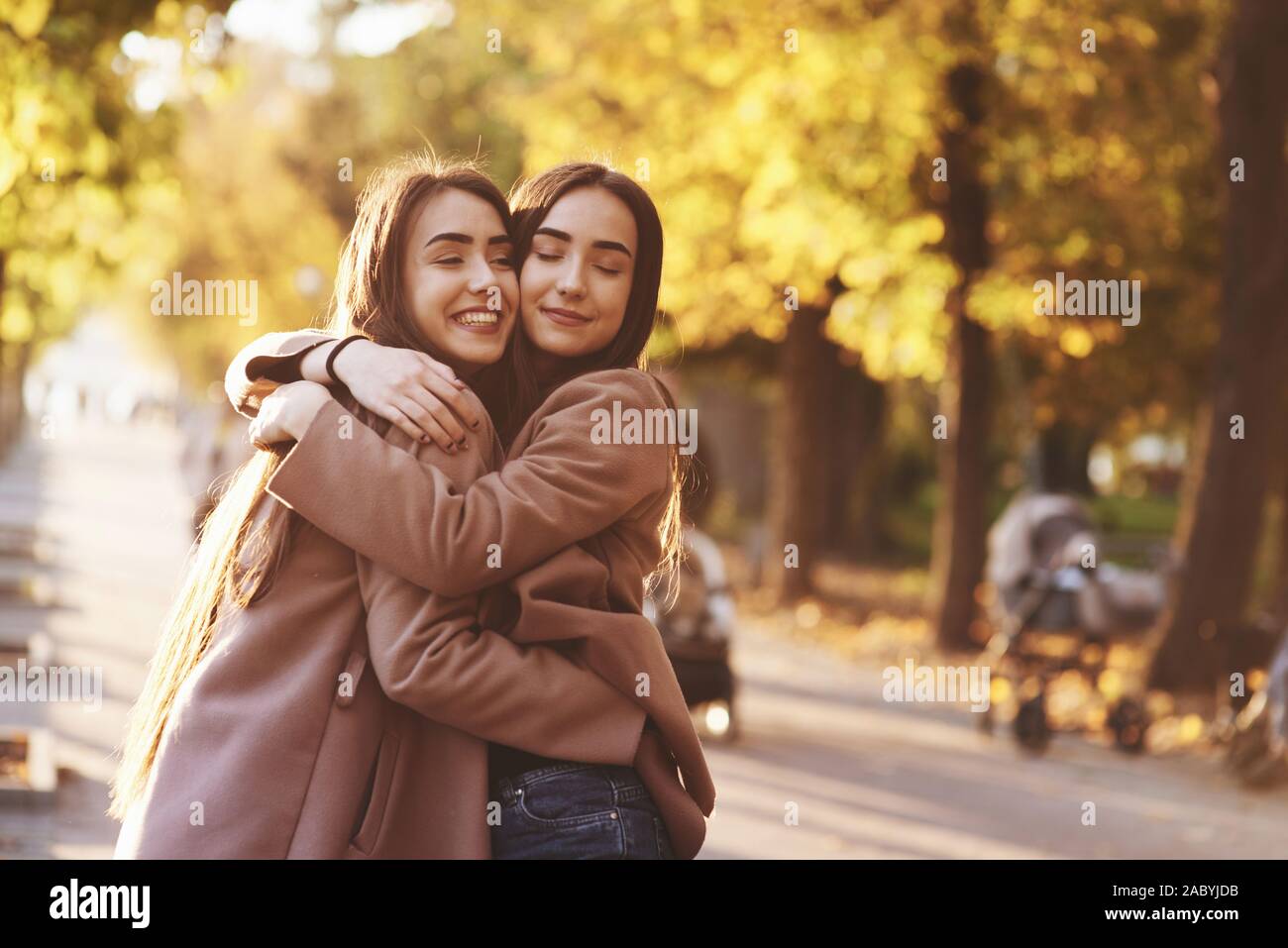 Two smiling twin sisters hugging hi-res stock photography and images ...