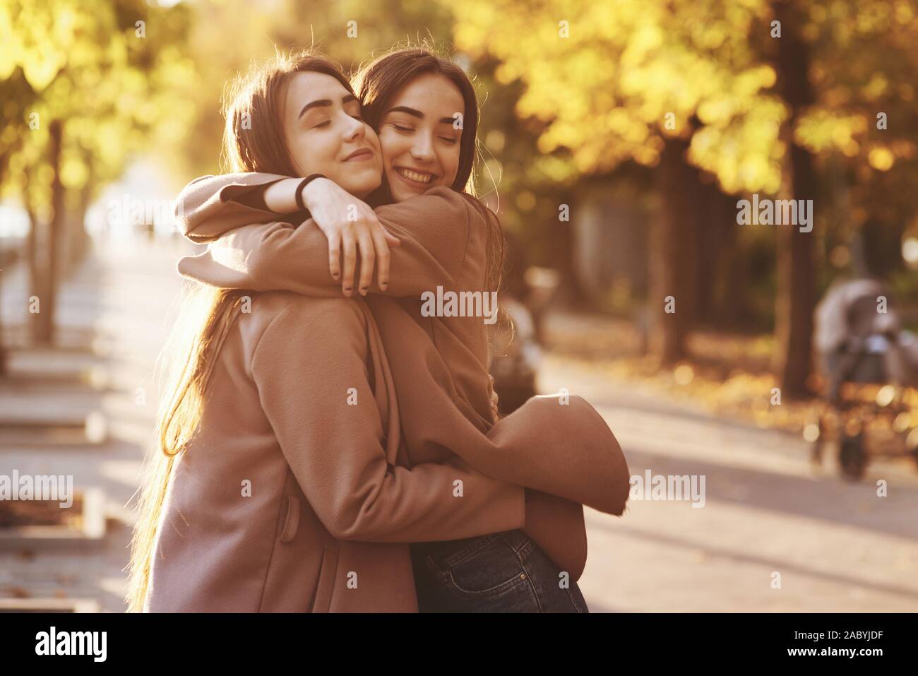 Two smiling twin sisters hugging hi-res stock photography and images ...