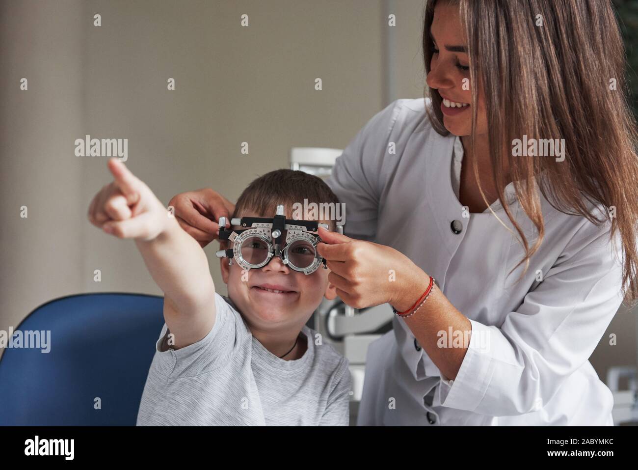 Smiling and reading. Child sitting in the doctor's cabinet and have ...
