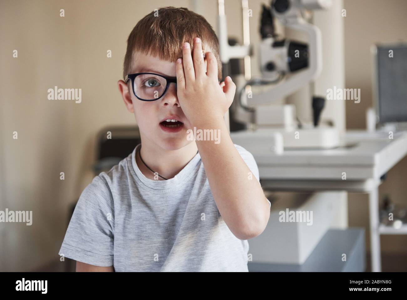 Tells what he see. Little boy covering his eye and having a look at the ...