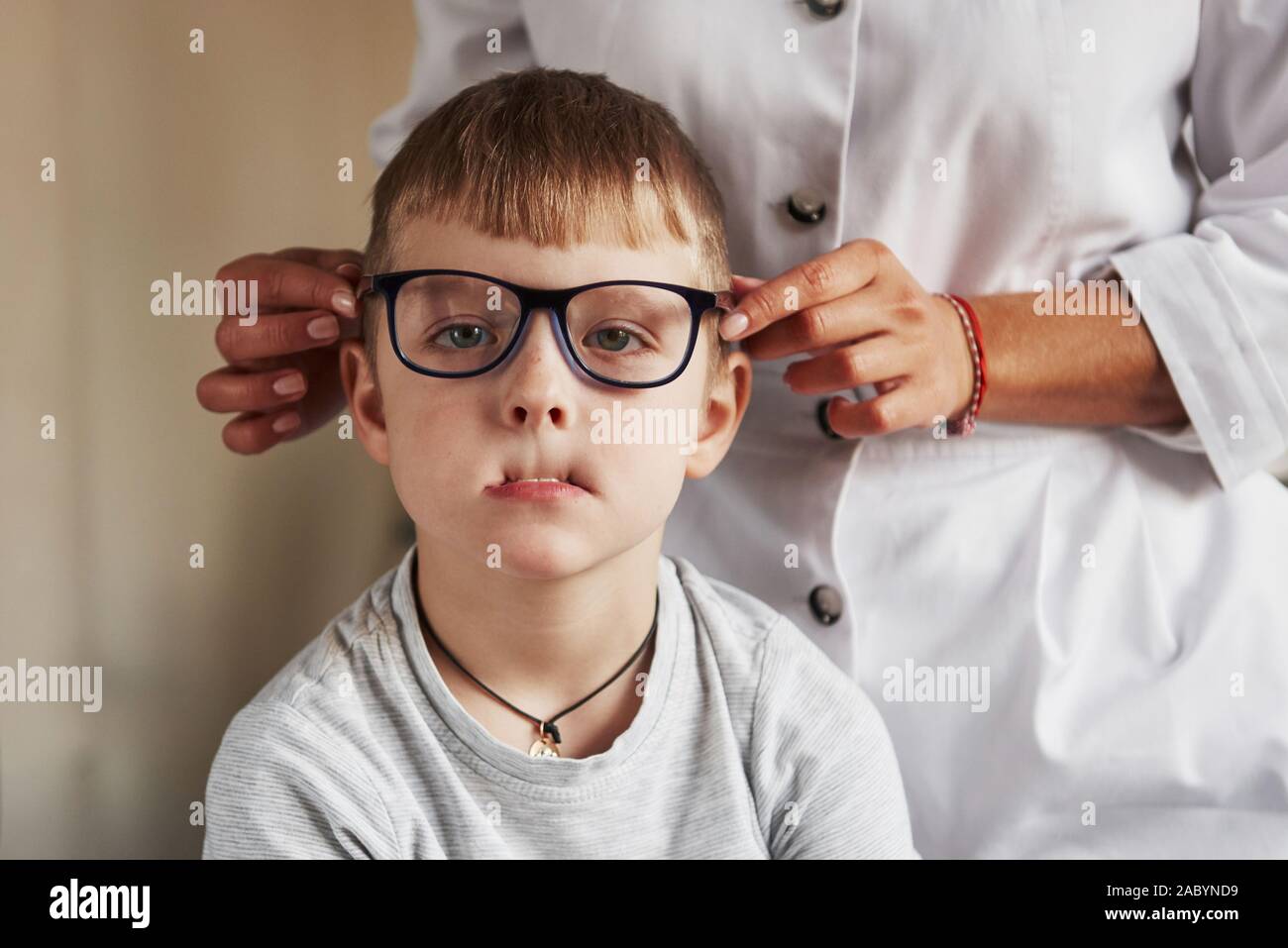 Child making faces to the camera. Kid sitting in the doctor office and ...