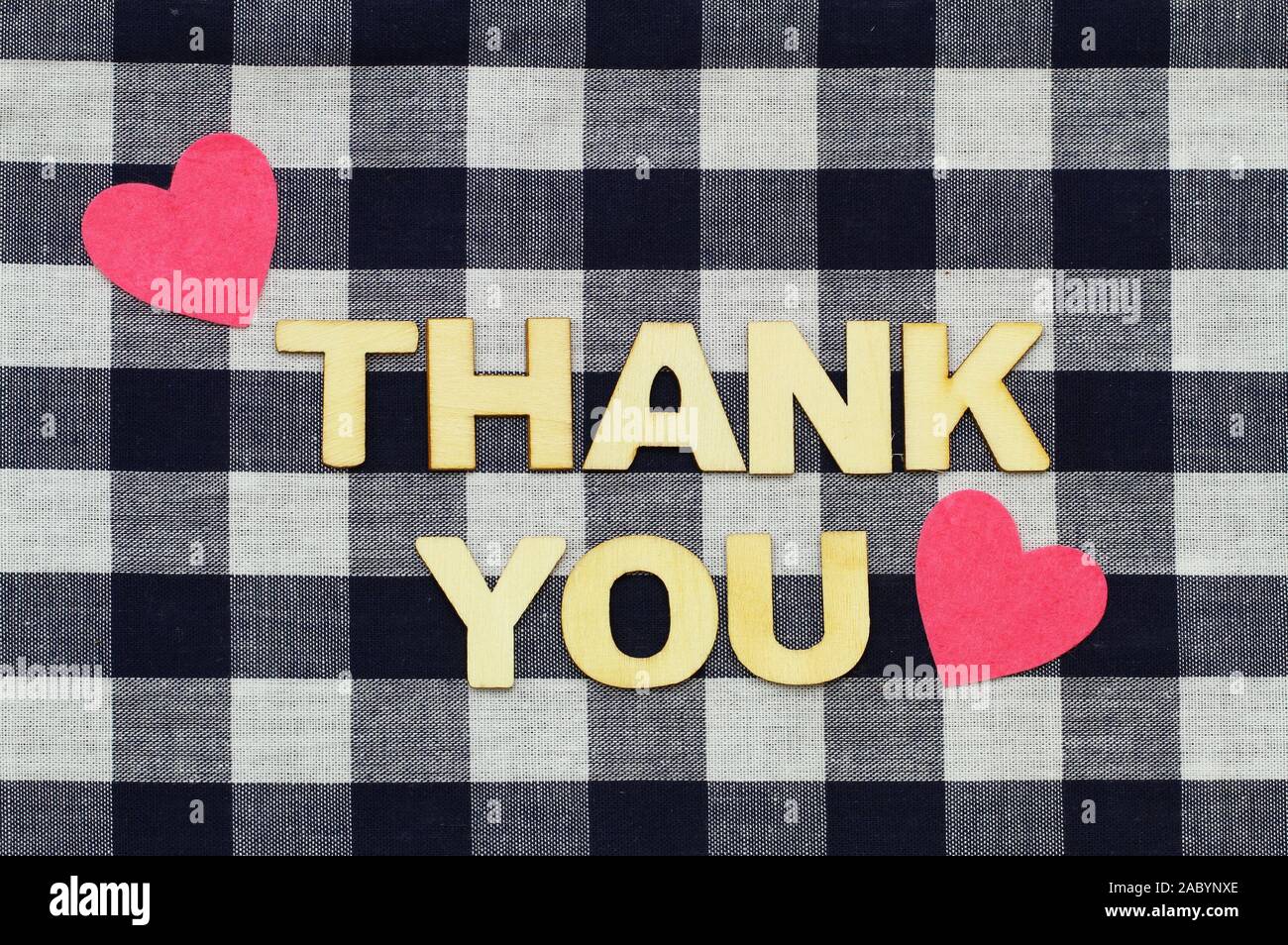 Thank you written with wooden letters on checkered cloth and pink ...