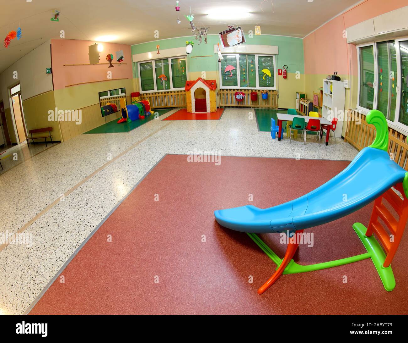 wide hall of a school with many toys and a plastic slide without ...