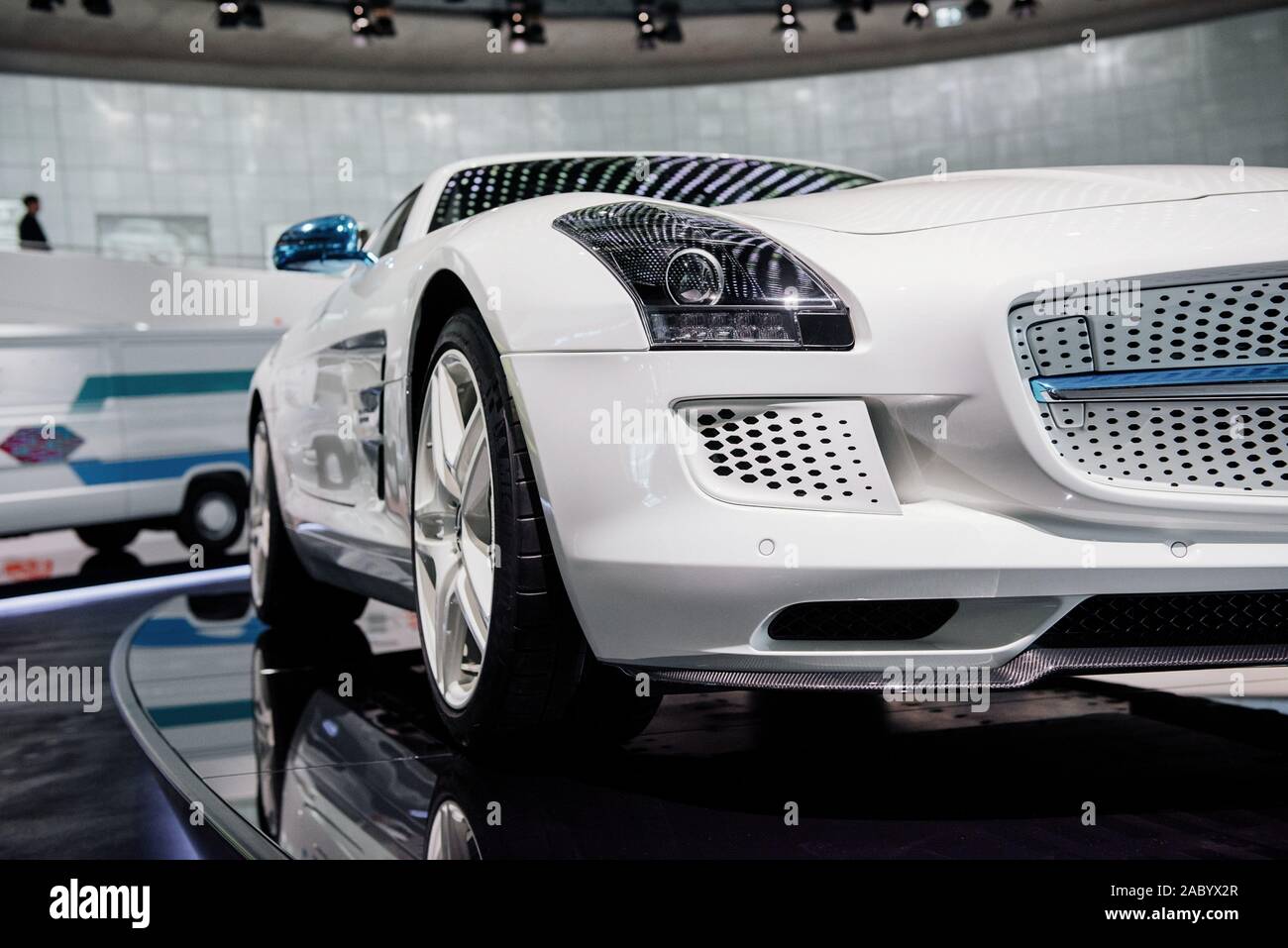 Front, side view of right headlight and radiator grille, blue mirror with turn signal, white ...