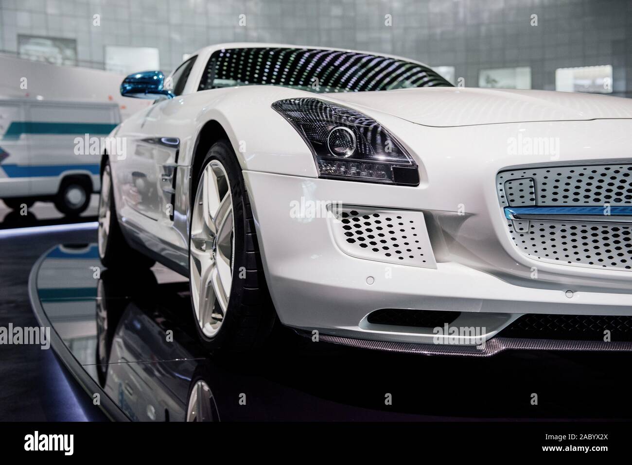 Front, side view of right headlight and radiator grille, blue mirror with turn signal, white ...