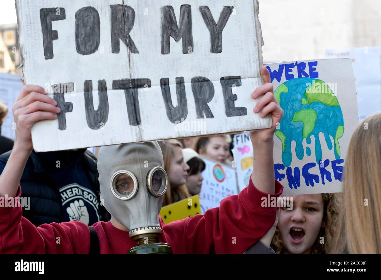 Environmental protester wearing a gas mask while holding a placard ...
