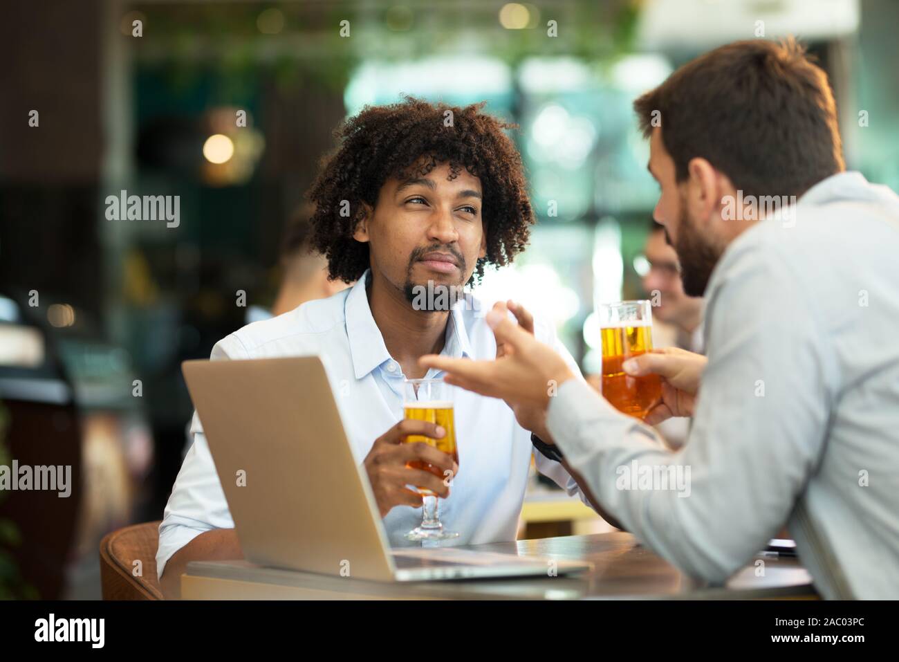 Young businessmen siting pub and drinking beer as they work Stock Photo ...