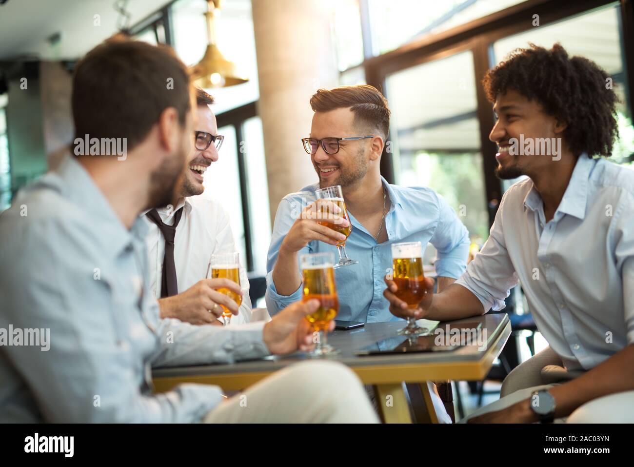 Funny conversation four businessmen while sit pub and drinking beer ...