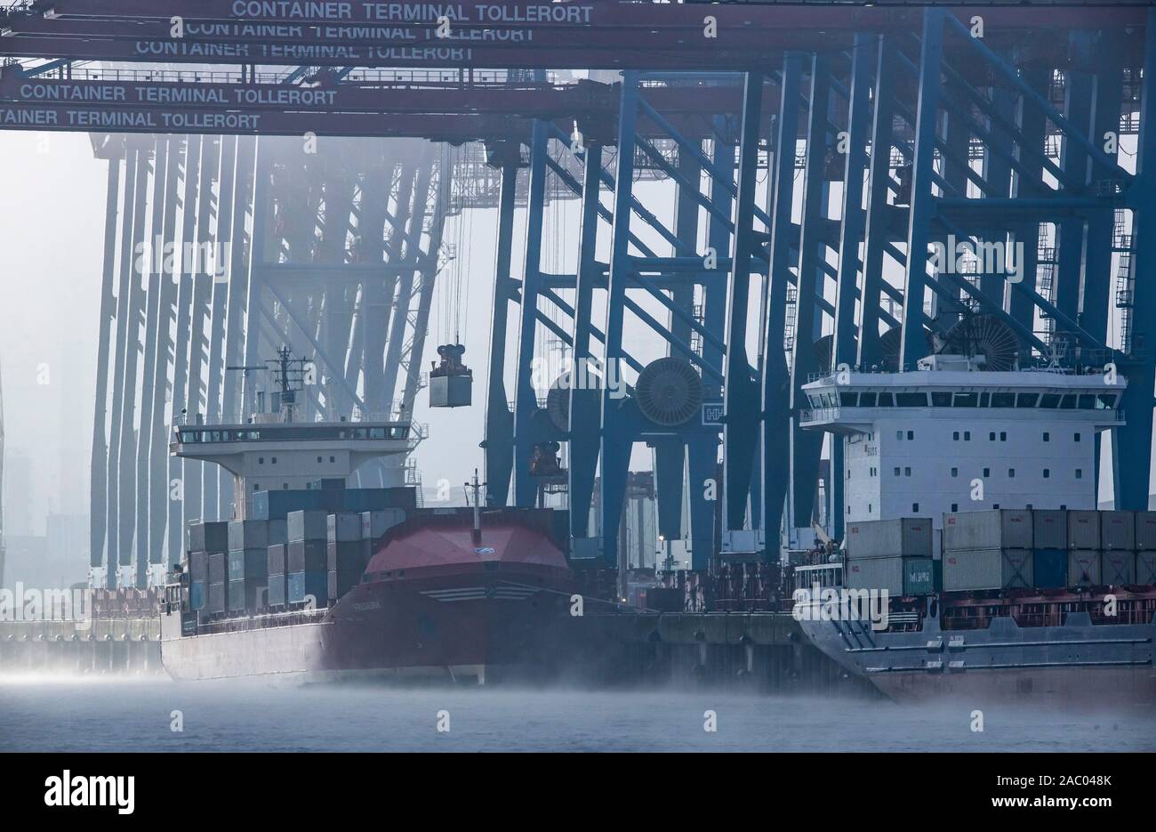 Container Terminal Tollerort in the Port of Hamburg, fog, container ship being loaded and ...