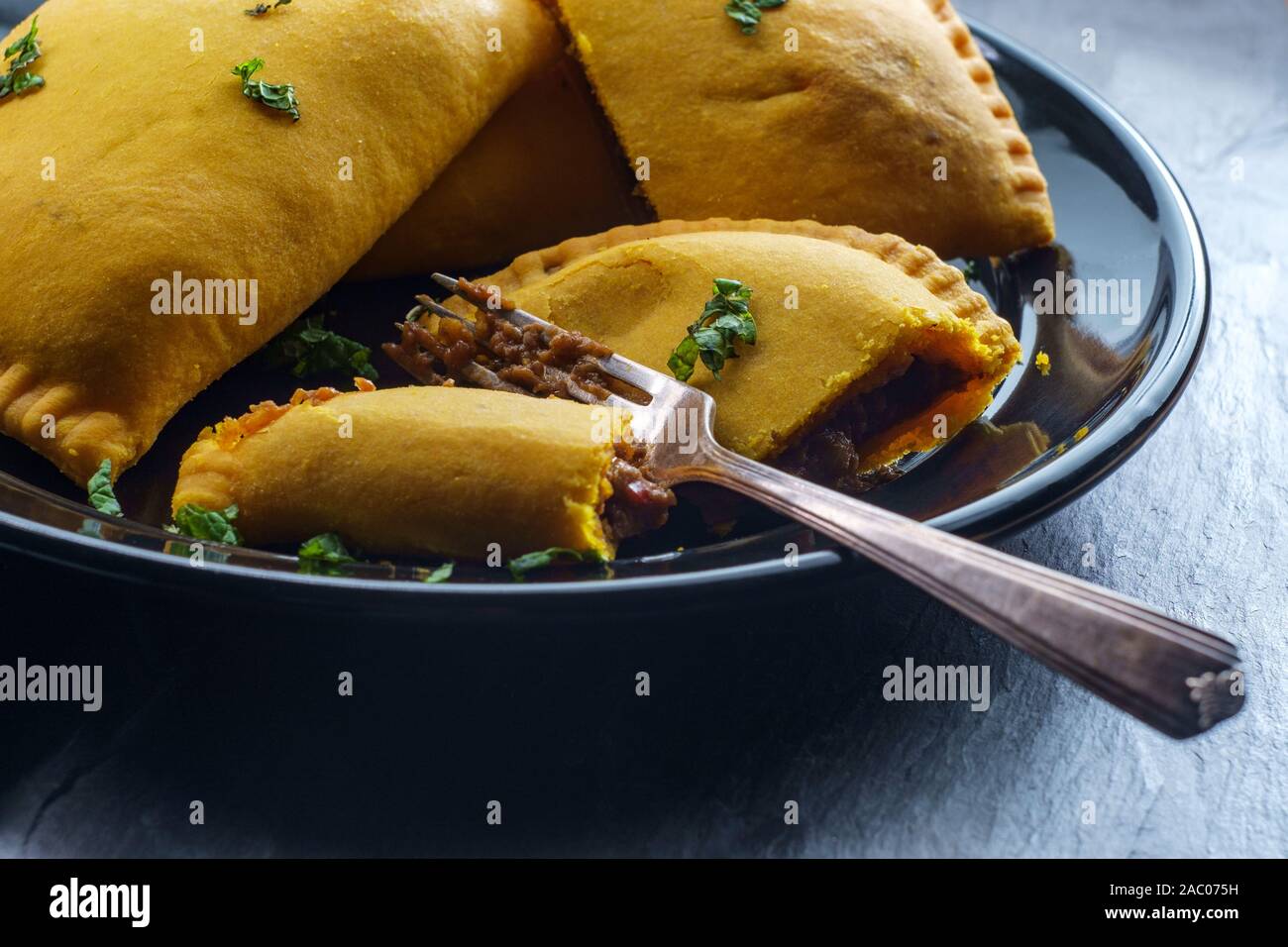 Spicy Jamaican beef turnovers with mint garnish Stock Photo - Alamy