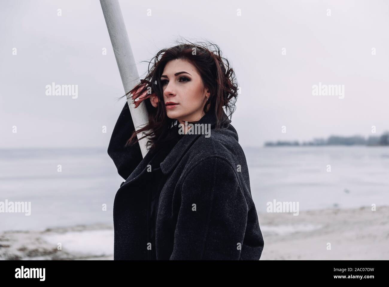 Young woman walking on cold windy winter beach Stock Photo - Alamy