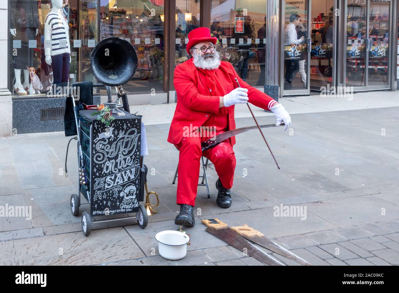 Santa on the saw, musician busker on high street, Christmas ...