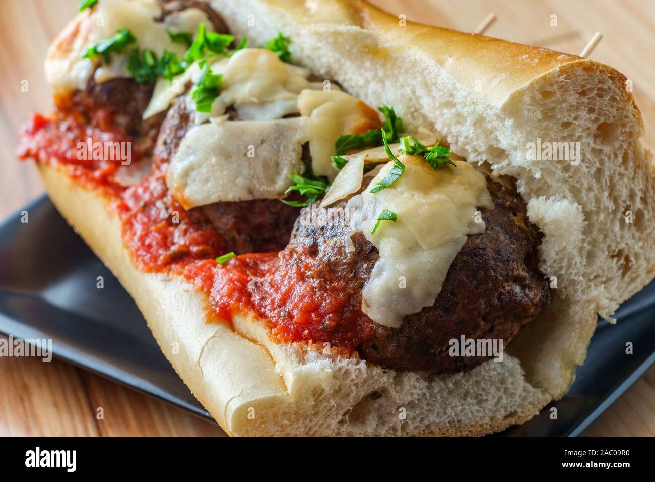 Italian meatball parmesan hero sandwich on a torpedo roll with parsley ...