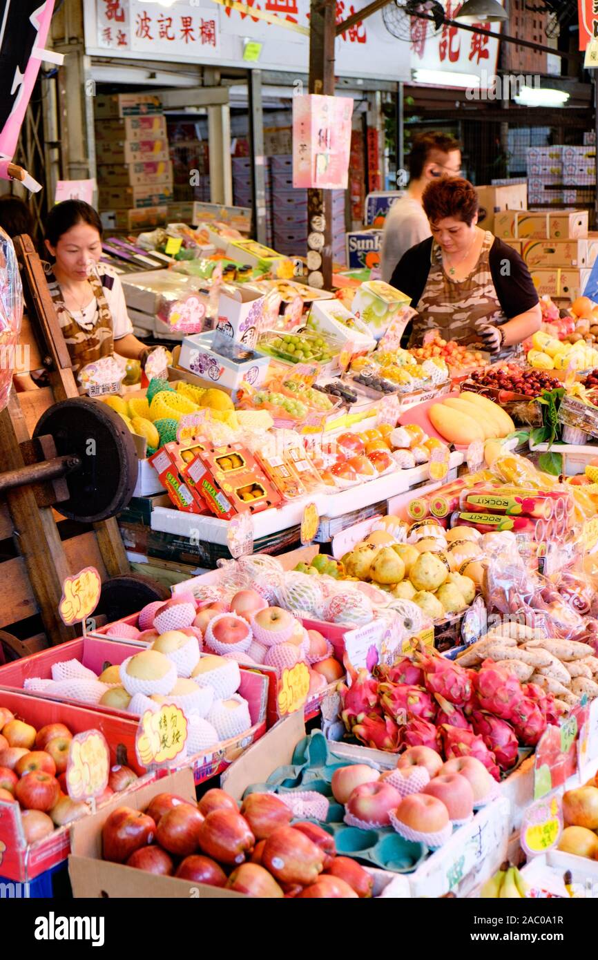 Vendors sell fresh fruit at a vibrant market. Shoppers browse the ...
