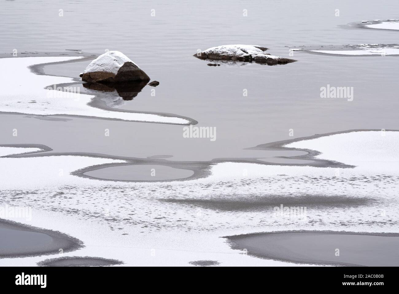 River begins to freeze, rocks poking out of the shallow water Stock ...