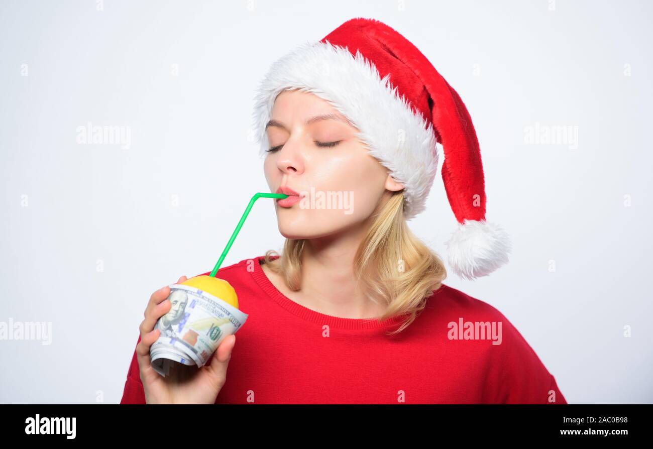 Girl santa hat drink juice lemon wrapped in banknote. Symbol of wealth ...