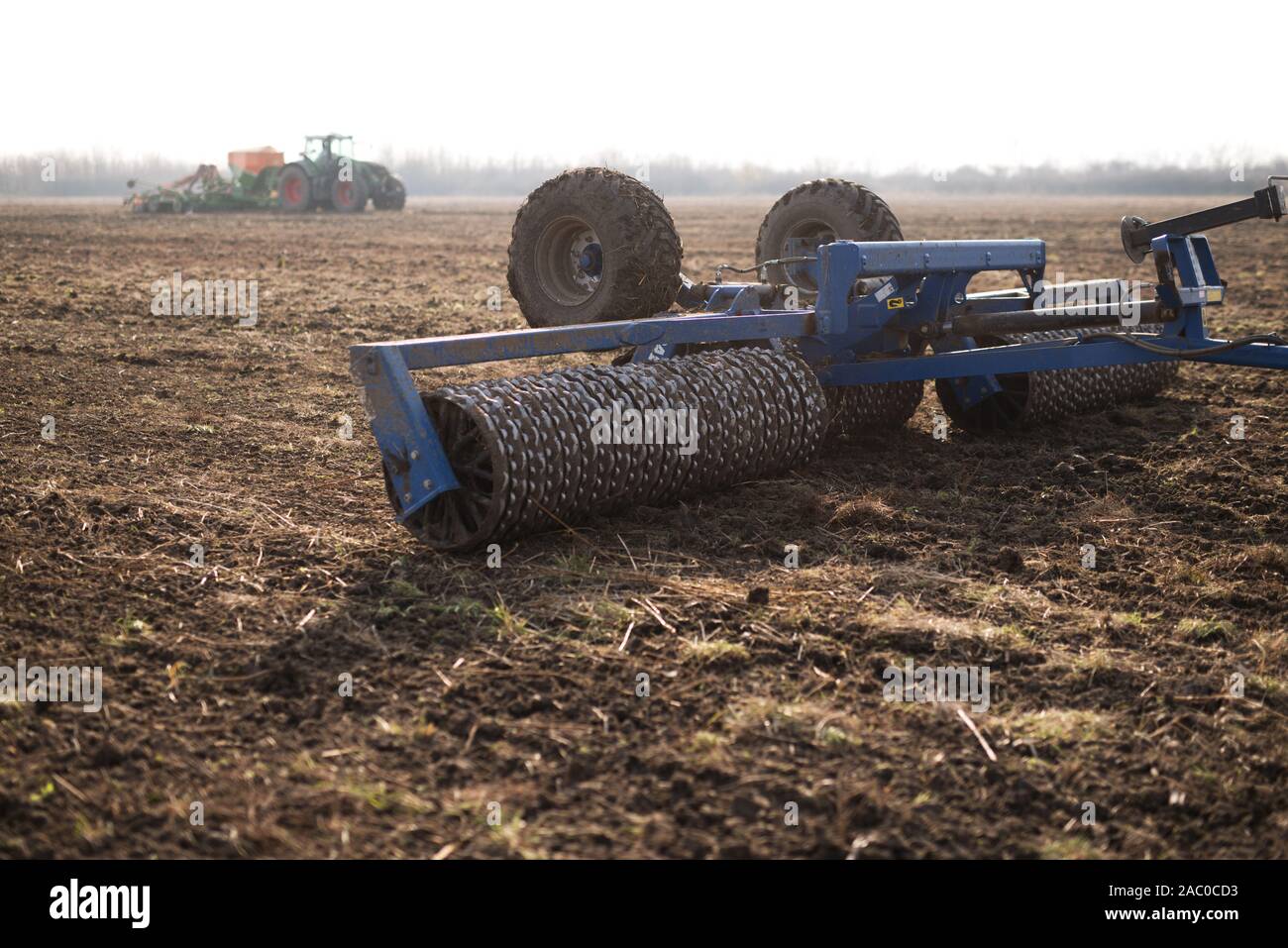 Tractor on the field cultivates the land Stock Photo - Alamy