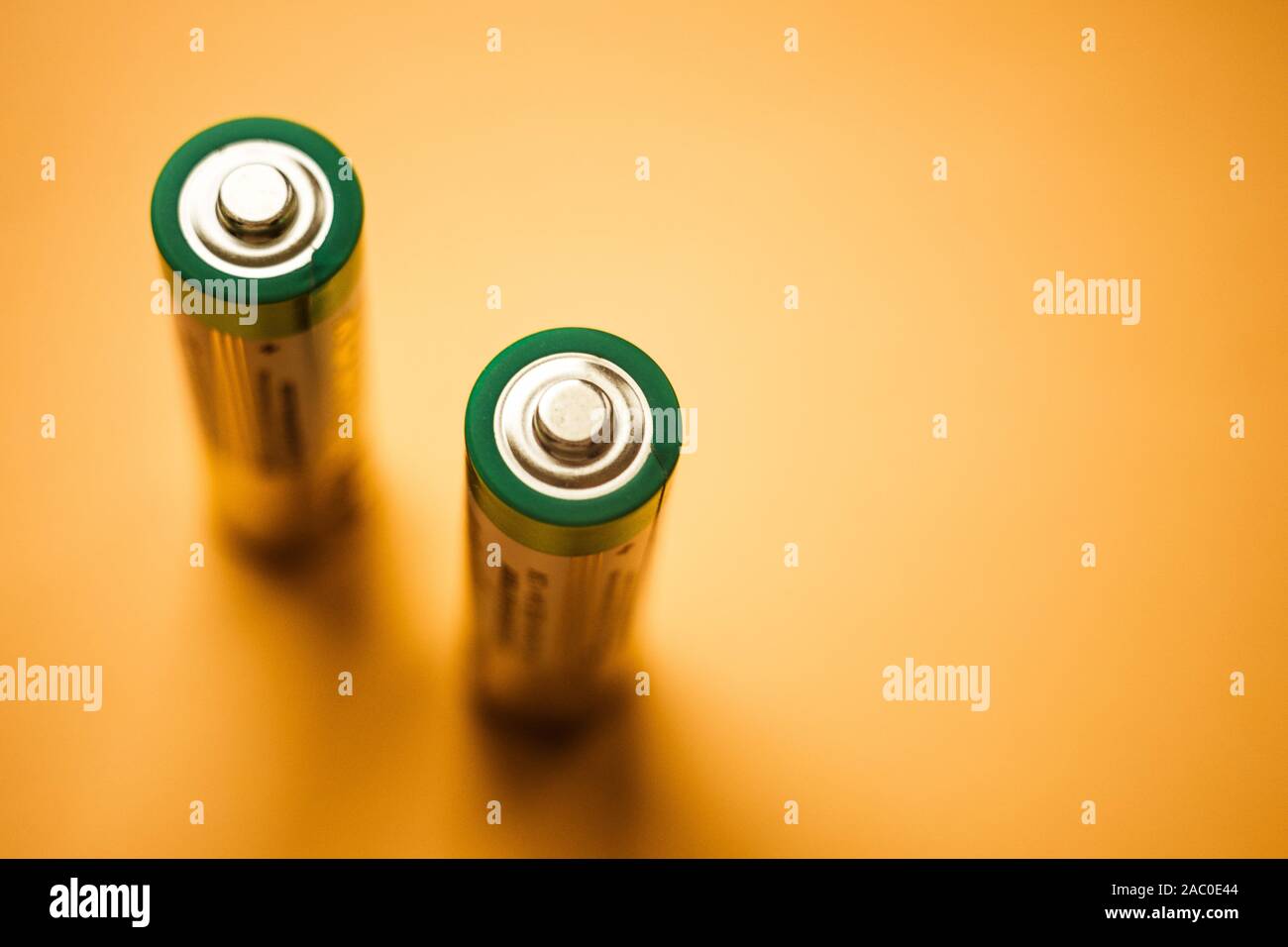 Two new batteries on the orange table, top view Stock Photo - Alamy