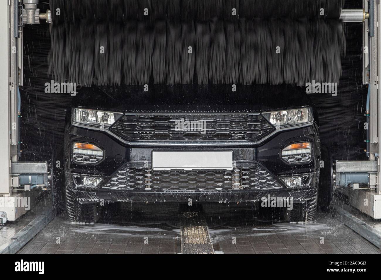 a black car stands in a car wash and is washed Stock Photo - Alamy
