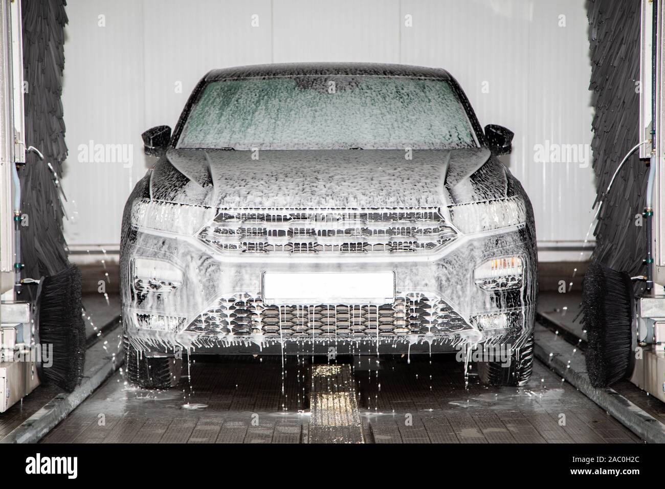 a black car stands in a car wash and is washed Stock Photo - Alamy