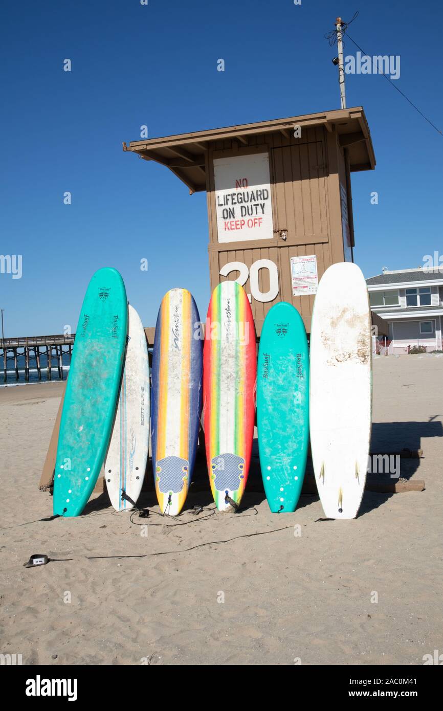 Line of surfboards standing against a lifeguard hut Newport pier ...