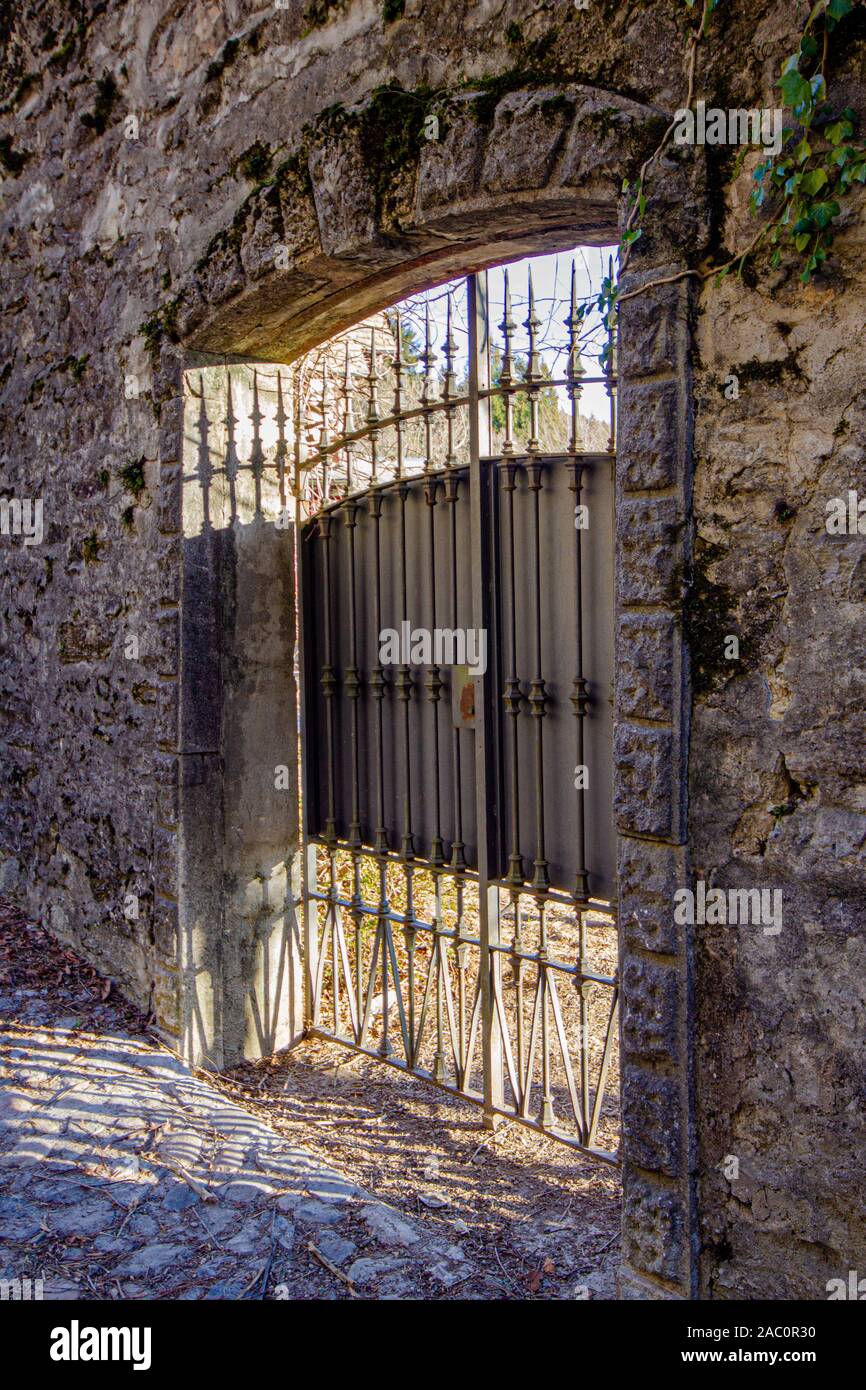 Ancient wrought iron gate with rust closed between old walls Stock ...