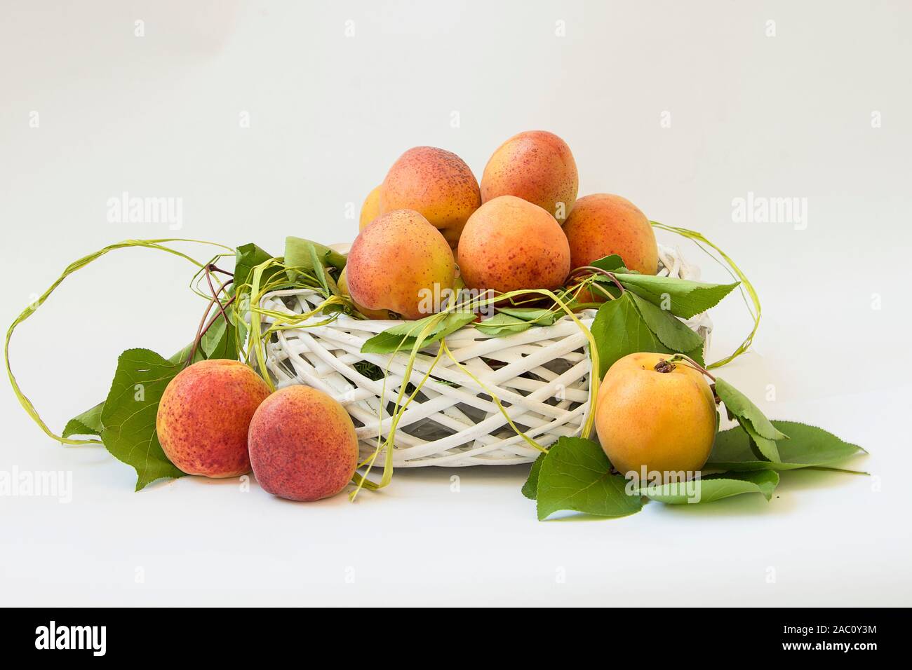 Fresh sweet apricots with leaves on white background Stock Photo - Alamy