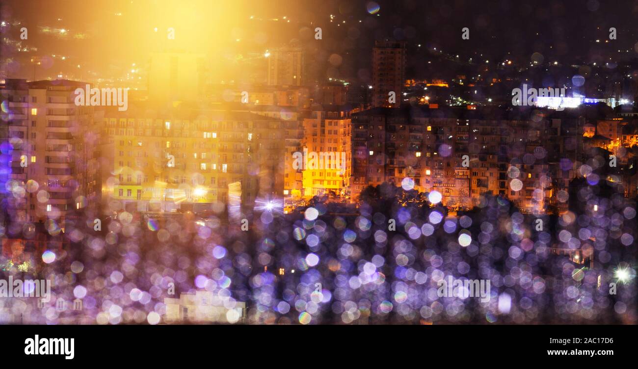 City in the rain at night. Window glass with raindrops defocused ...
