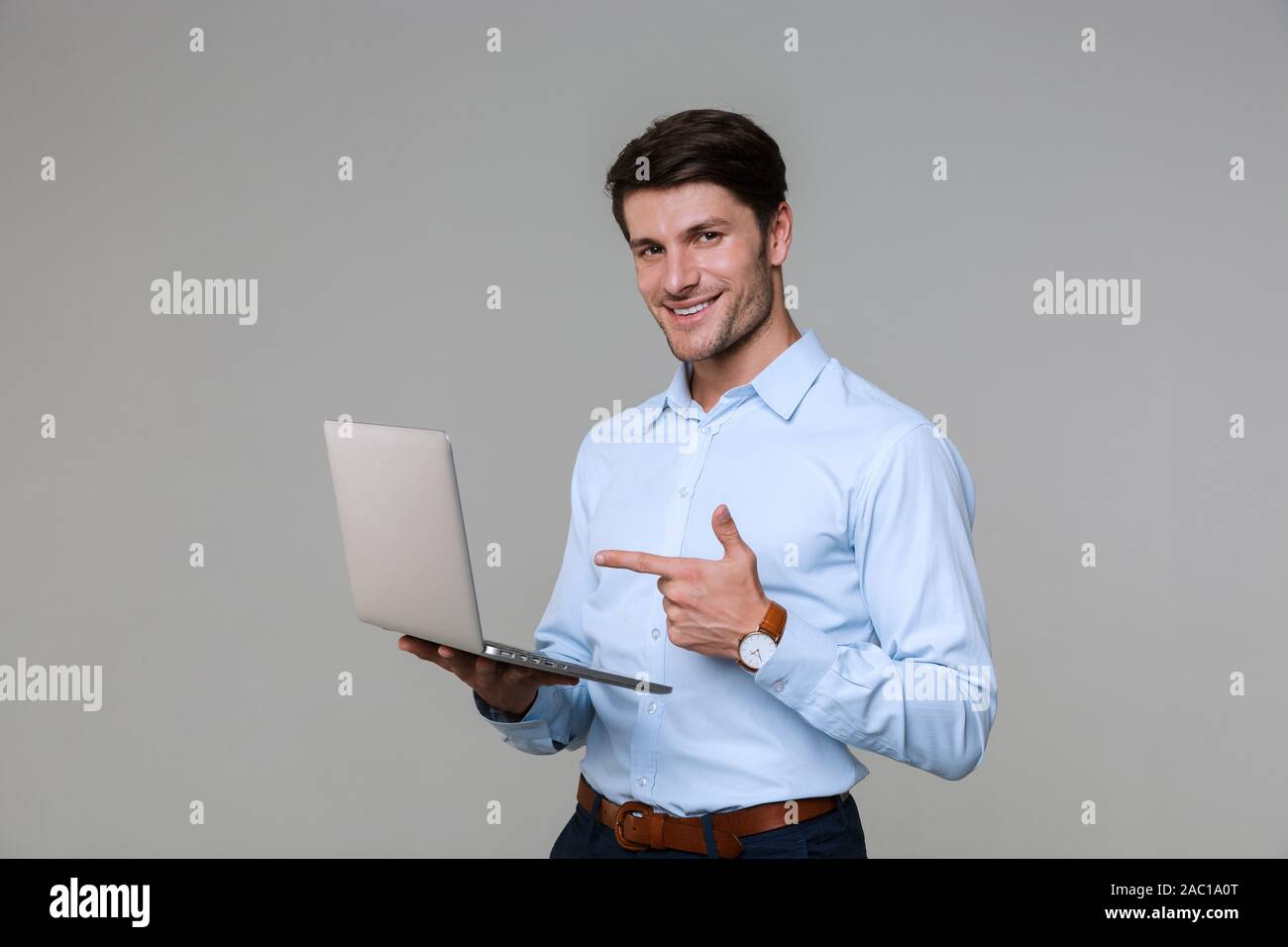 Image of joyful businessman pointing finger at screen while holding ...