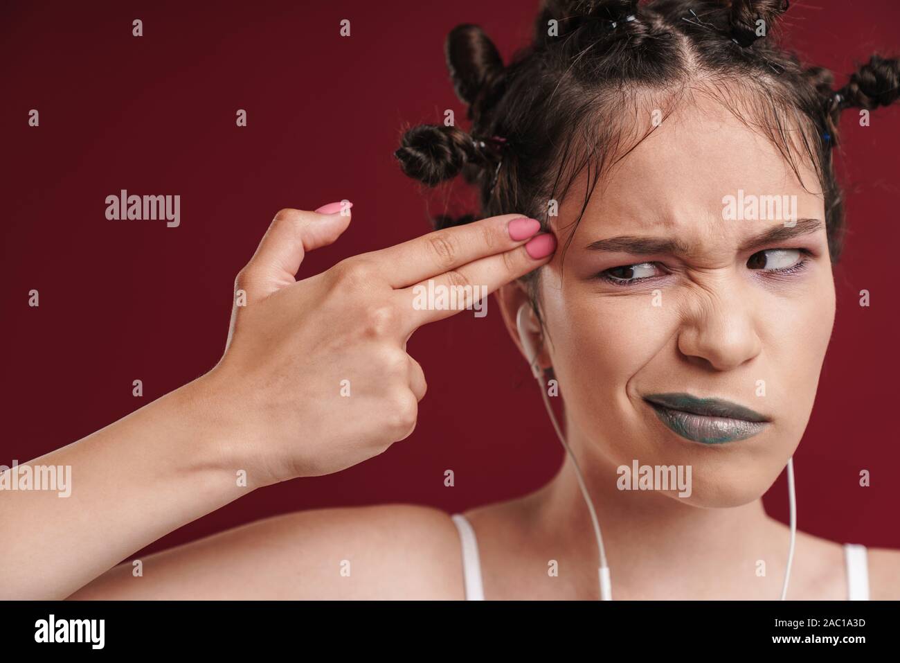 Closeup picture of a young confused punk teenage girl listening music ...