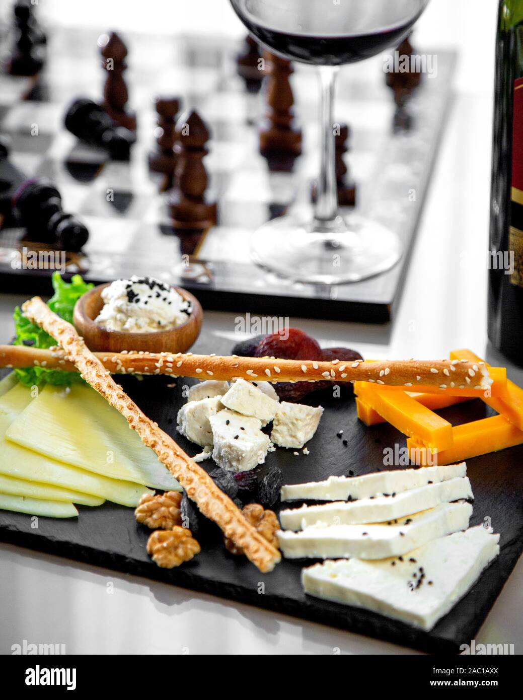 cheese board with cheddar, parmesan, white cheese and breadsticks Stock ...