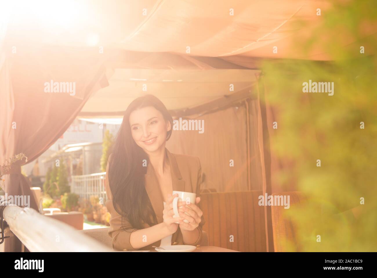 Charming young woman enjoying tea in cafe Stock Photo - Alamy