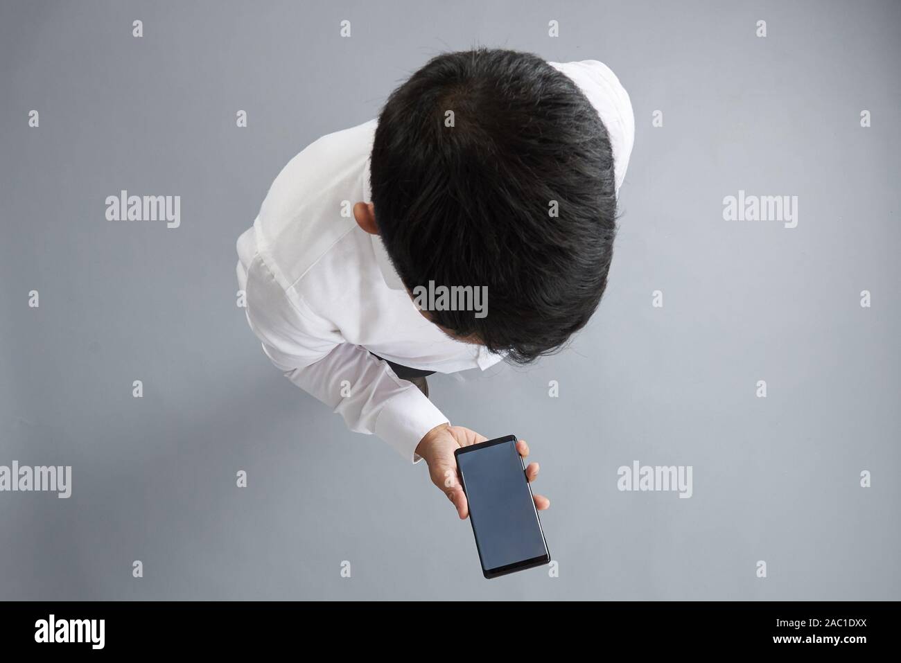 Man look at smartphone above top view on gray studio background Stock ...